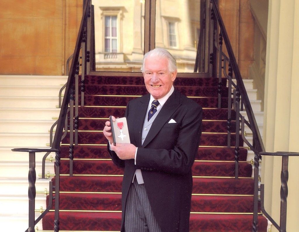 Angus Cundey presented his MBE medal by The Queen - Henry Poole Savile Row